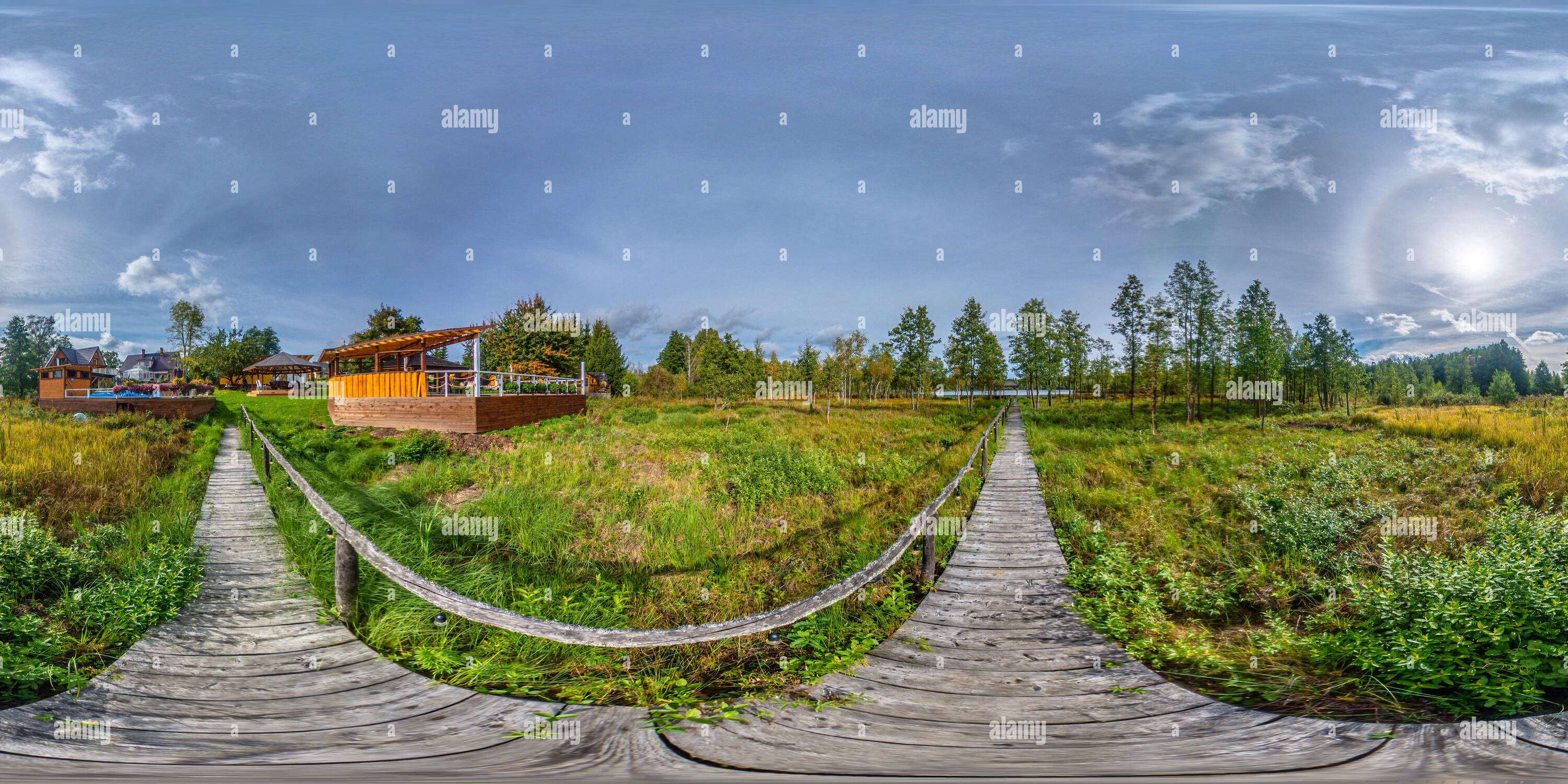 360° view of Sunny wooden path to the lake at a holiday home - Alamy