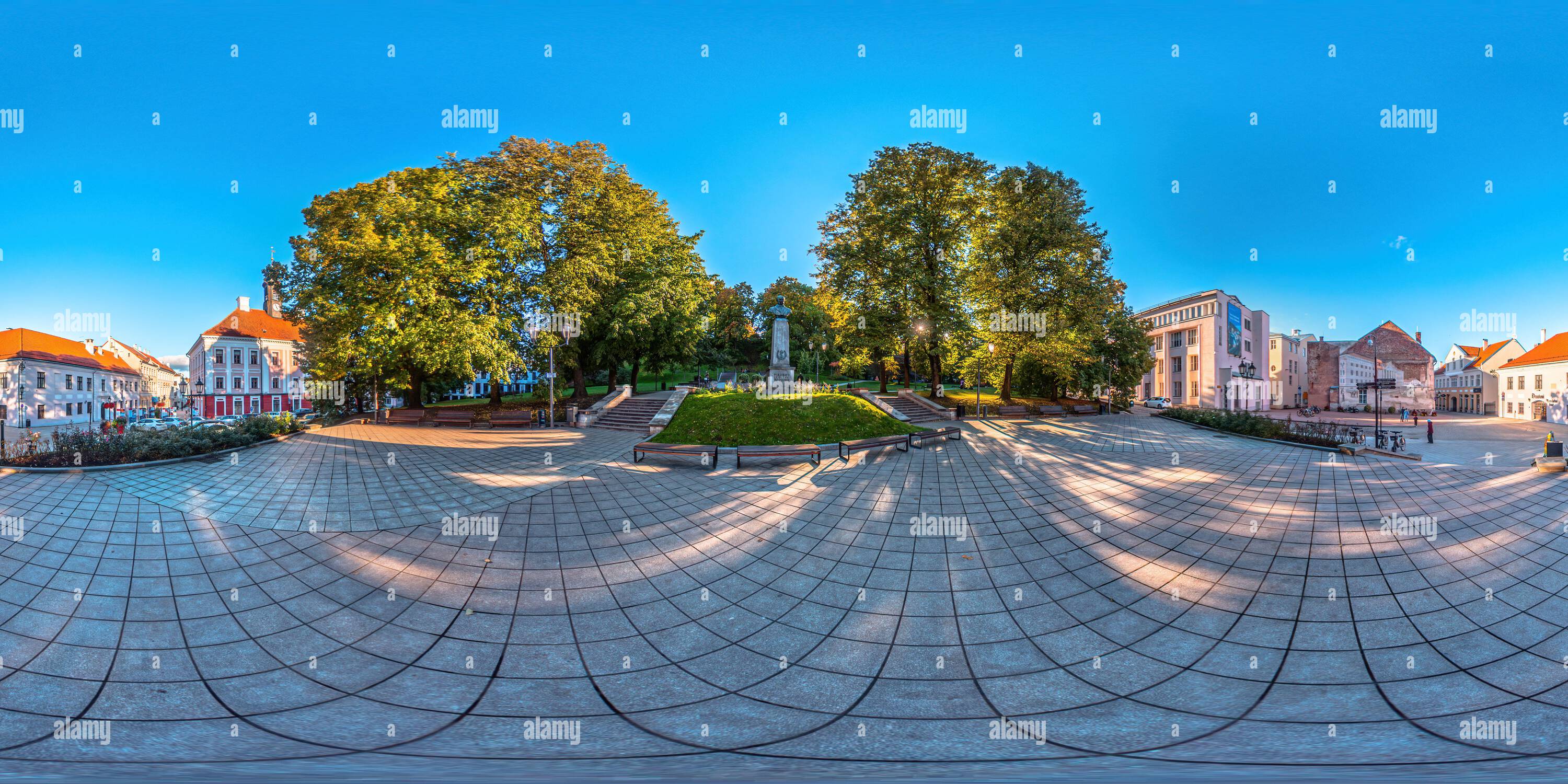 360° view of Autumn park with sunshine, shadows, benches and a monument ...