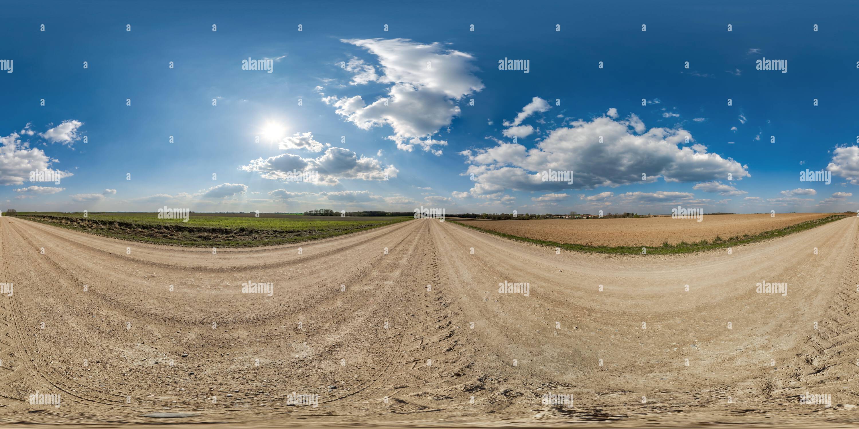 360° view of spherical 360 hdri panorama on gravel road with clouds and sun on blue sky in ...