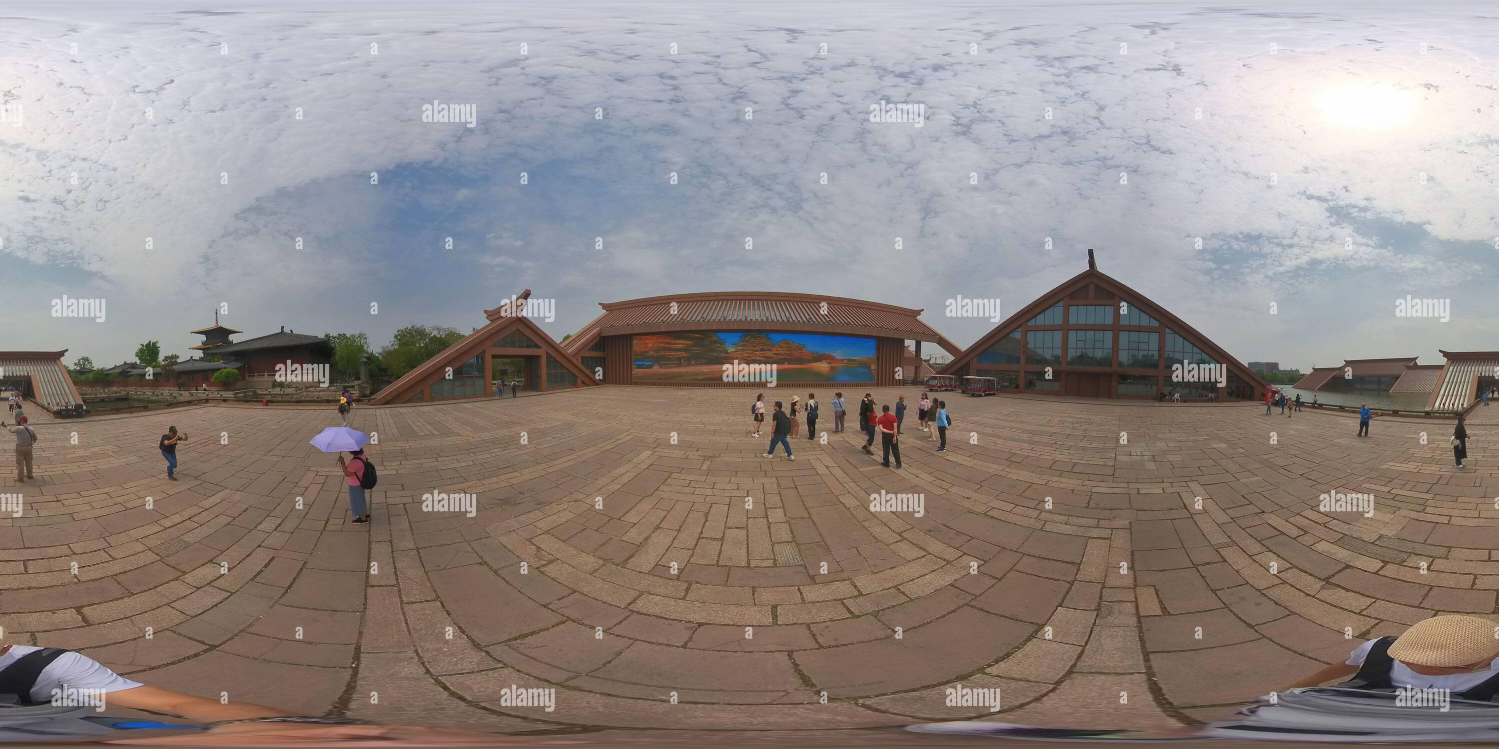 360° view of 360 view of Visitors walk through a modern, sloped-roof ...