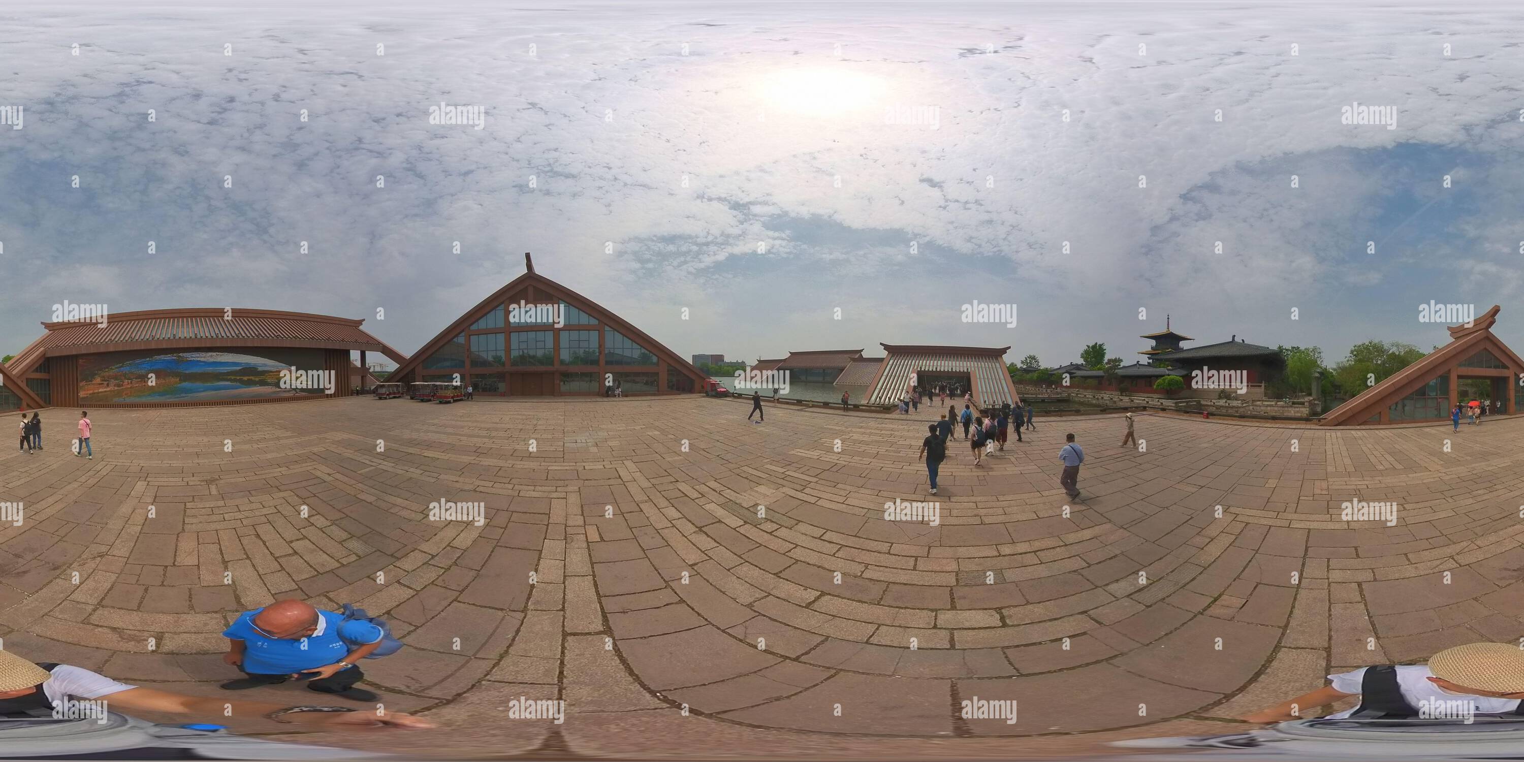 360° view of 360 view of Visitors walk through a modern, sloped-roof ...